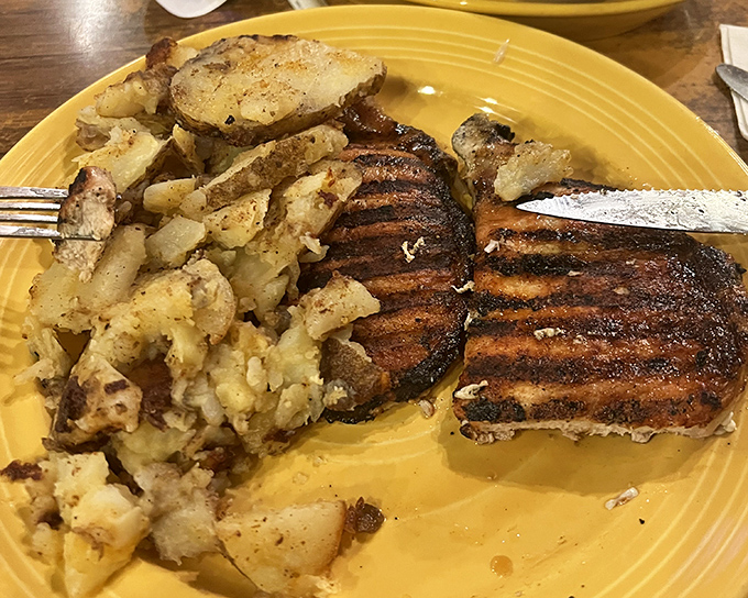 These aren't just pork chops—they're the reason people drive miles out of their way, perfectly seared and served with home fries that deserve their own fan club.