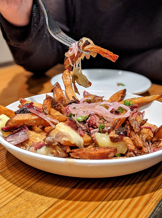 Loaded fries topped with cheese and bacon create the kind of indulgent comfort food that defies all logic.