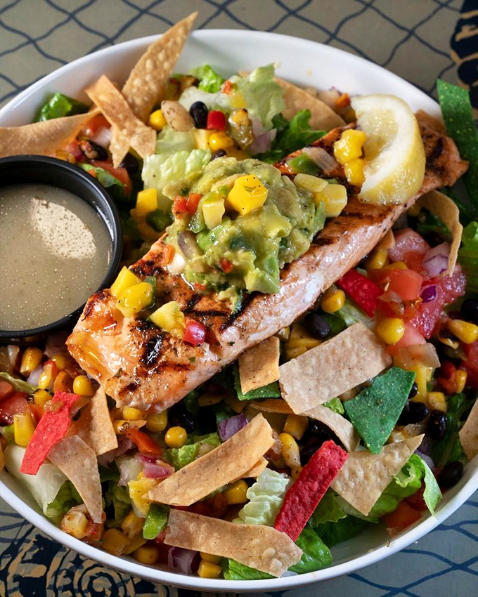 A salad that doesn't apologize for being healthy &ndash; grilled salmon and colorful tortilla strips creating a fiesta on your plate.