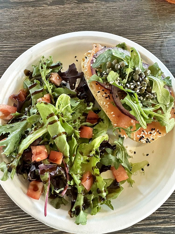 A bagel topped with fresh greens and salmon—breakfast elevated from mundane to magnificent in one beautiful bite.