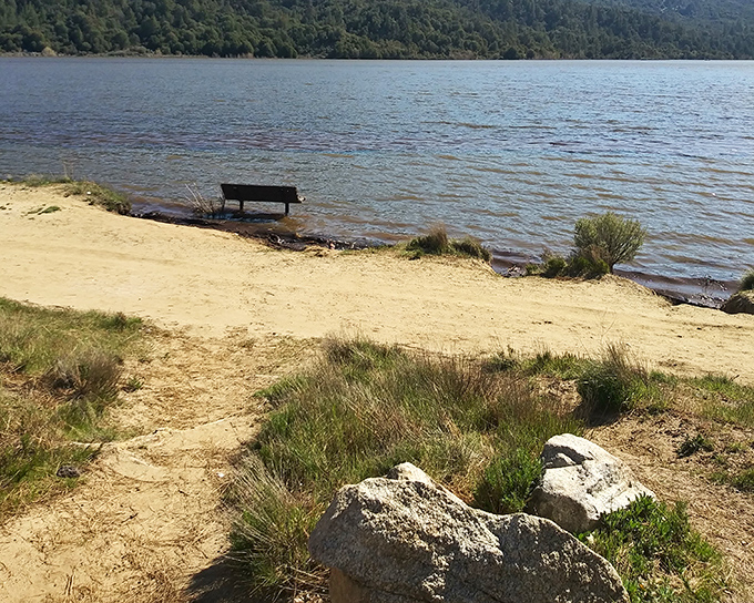 A lone bench faces the vastness of Lake Hemet, patiently waiting for someone to sit and appreciate the view it enjoys every day.