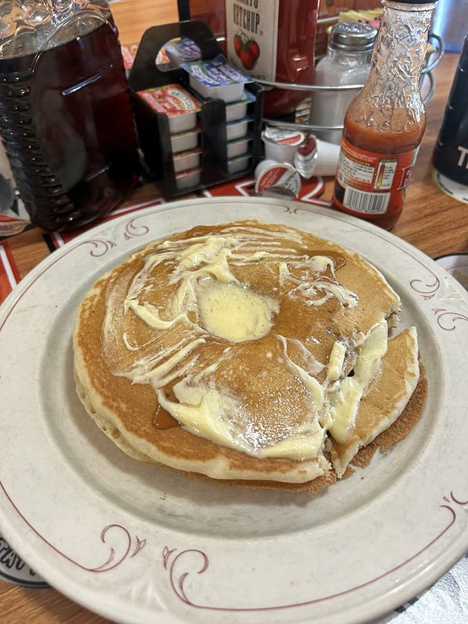 Pancakes aren't just breakfast&mdash;they're blank canvases for butter rivers and maple syrup lakes. Pure morning artistry on a classic diner plate.