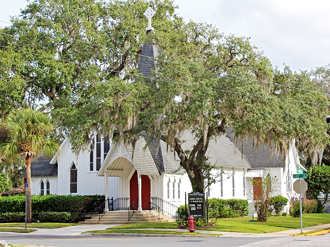 St. James Episcopal Church stands serenely beneath Spanish moss, its white walls and red doors a testament to old Florida charm.