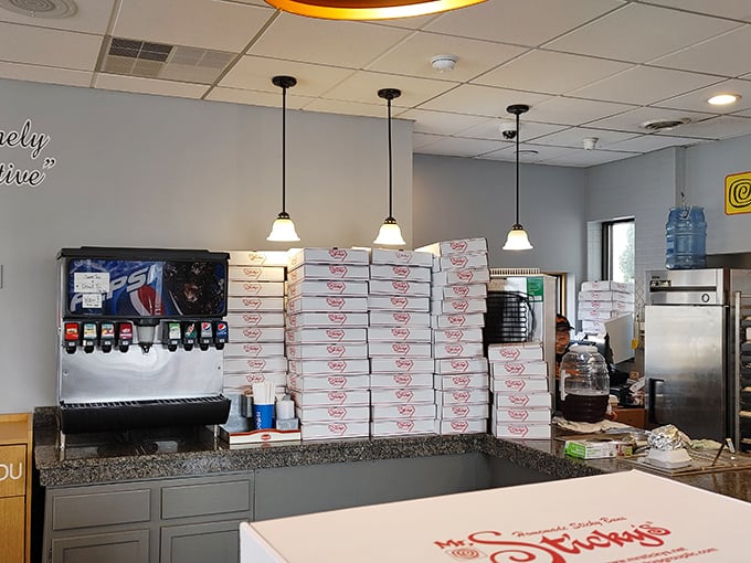 The tower of take-home boxes speaks volumes. Nobody buys just one sticky bun, and nobody regrets buying a dozen.