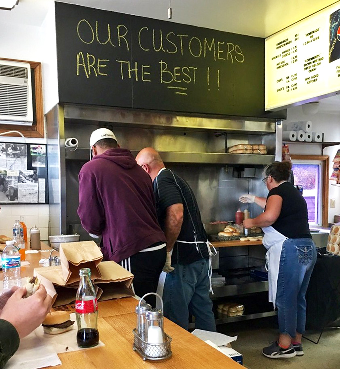 "Our customers are the best!!" proclaims the chalkboard, as the kitchen crew works their magic. In the burger business, truer words were never written.