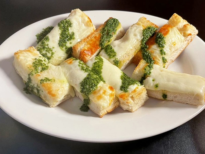 Cheese toast reimagined as a work of art. The pesto drizzle isn't just garnish&mdash;it's the signature on a masterpiece of melty perfection.