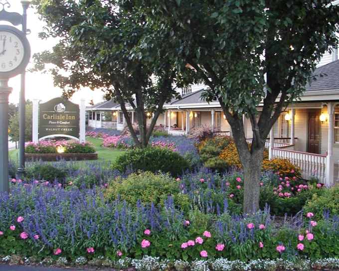 Garden paradise at the Carlisle Inn. Lavender, roses, and perfectly manicured shrubs create a welcome that begins long before you reach the door.
