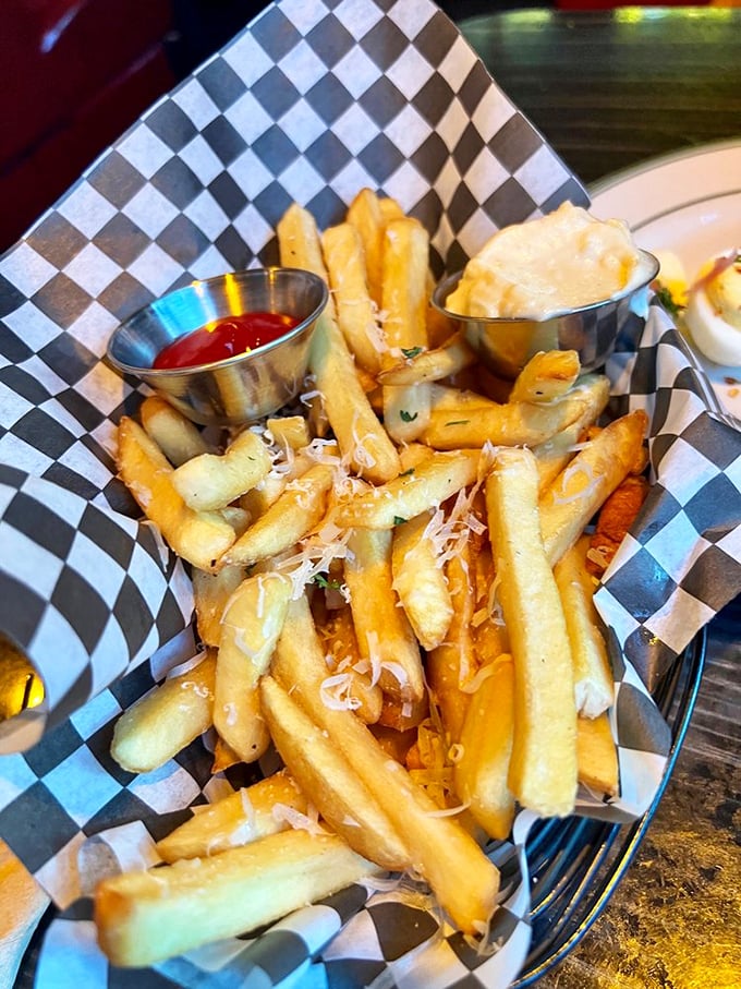 These aren't just fries; they're potato royalty wearing a parmesan crown. The checkered paper is just trying to contain their majesty while they await the ketchup plunge.