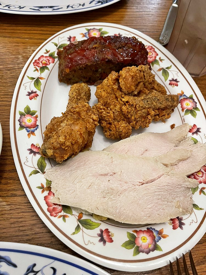 The holy trinity of Southern comfort: meatloaf with sweet glaze, golden fried chicken, and sliced turkey&mdash;a plate that says "nap time follows immediately."