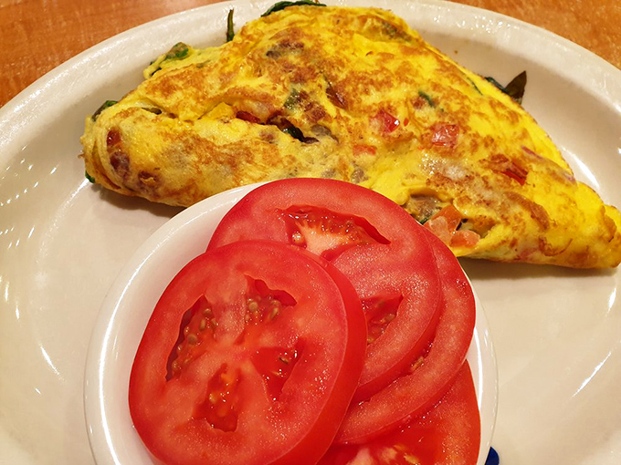 An omelet that's clearly been to the farmer's market and back, with tomato slices so perfect they deserve their own Instagram.