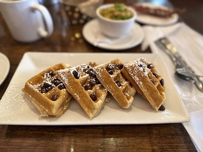 Waffles with chocolate chips that didn't just fall in by accident. They're strategically placed little pockets of joy, dusted with powdered sugar like fresh snow.