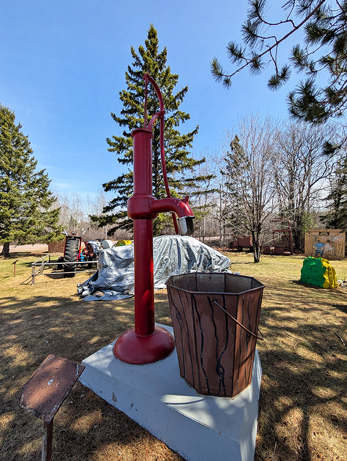 An old-fashioned water pump stands ready, like a stoic guardian of simpler times when getting a drink required actual physical effort.