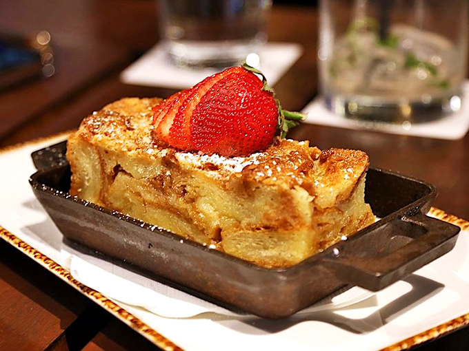 Bread pudding that transforms humble ingredients into something transcendent, topped with a strawberry that's just showing off at this point.