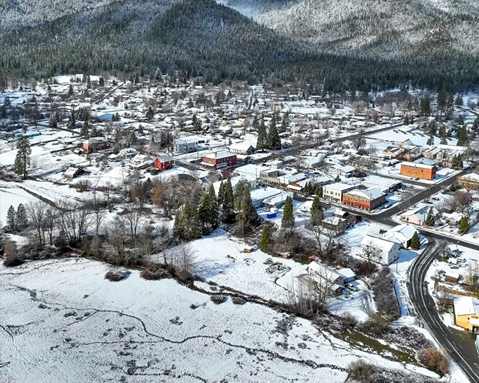 Etna's aerial winter landscape looks like a Christmas card waiting to happen. Snow blankets the town in peaceful white silence.