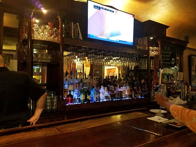 At this bar, bourbon flows like conversation and crystal glassware dangles like chandelier jewels. Mixology meets history in liquid form.