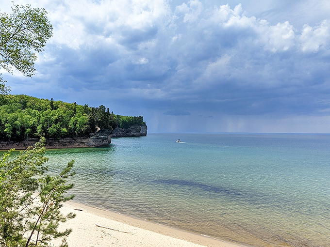 Storm clouds gather over tranquil waters, creating that dramatic lighting photographers dream about and casual visitors accidentally capture on their phones.