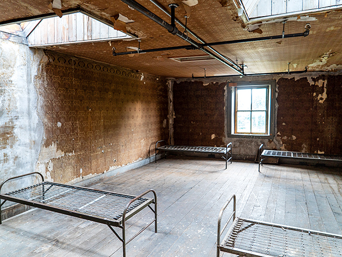 Simple metal bed frames stand as silent witnesses to countless nights of institutional living, their spartan design speaking volumes about priorities past.