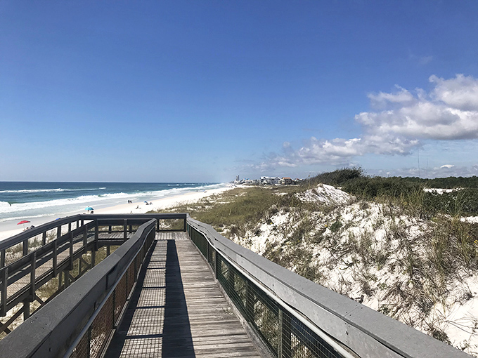 The boardwalk beckons like a runway to heaven, guiding visitors over protected dunes to that first breathtaking glimpse of turquoise.