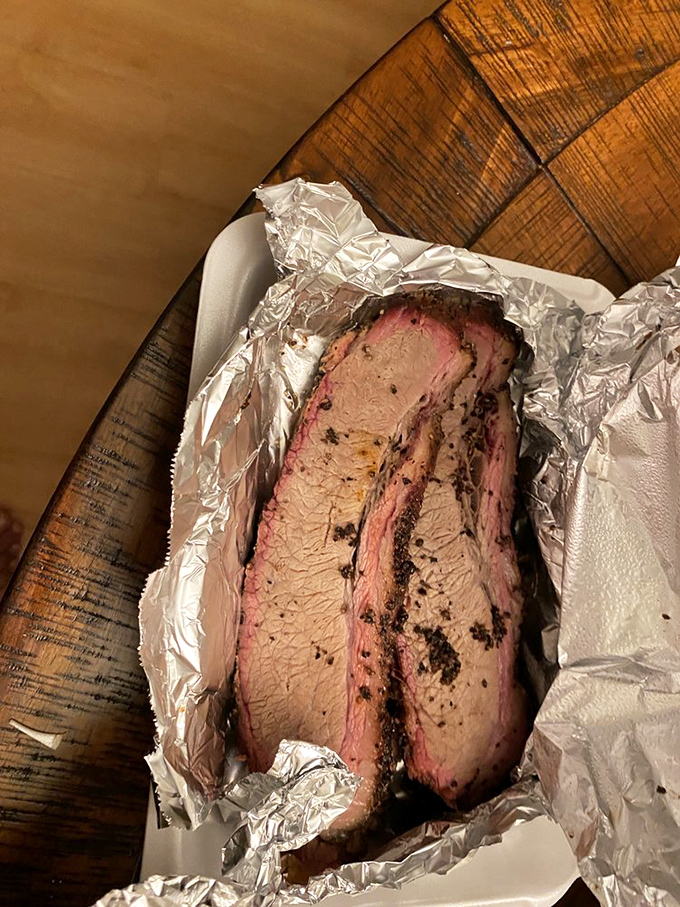 Foil-wrapped brisket revealing that coveted pink smoke ring&mdash;evidence of a 14-hour love affair between beef and smoldering wood.