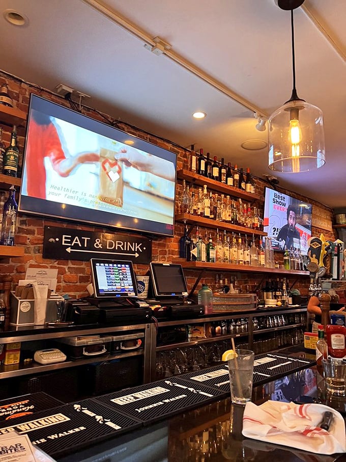 Behind the bar, bottles line up like soldiers ready for duty, beneath the "EAT & DRINK" command that nobody needs to be told twice.