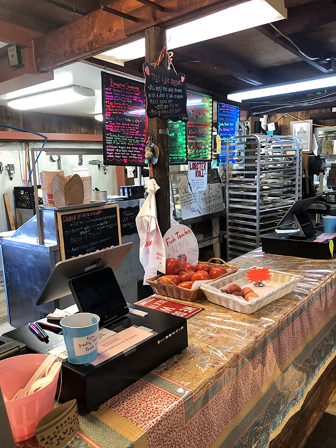 Behind this counter, magic happens daily. Fresh tomatoes waiting their turn while colorful menu boards announce the day's treasures.