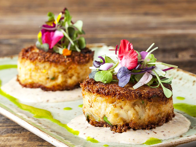 Crab cakes so perfectly golden they deserve their own California sunset, adorned with microgreens that add both color and conscience.