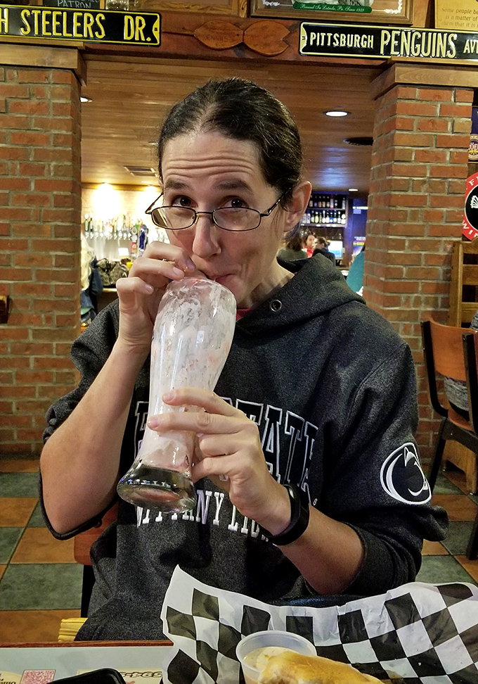 The face of someone who just realized their beverage is merely the opening act to a burger of legendary proportions.