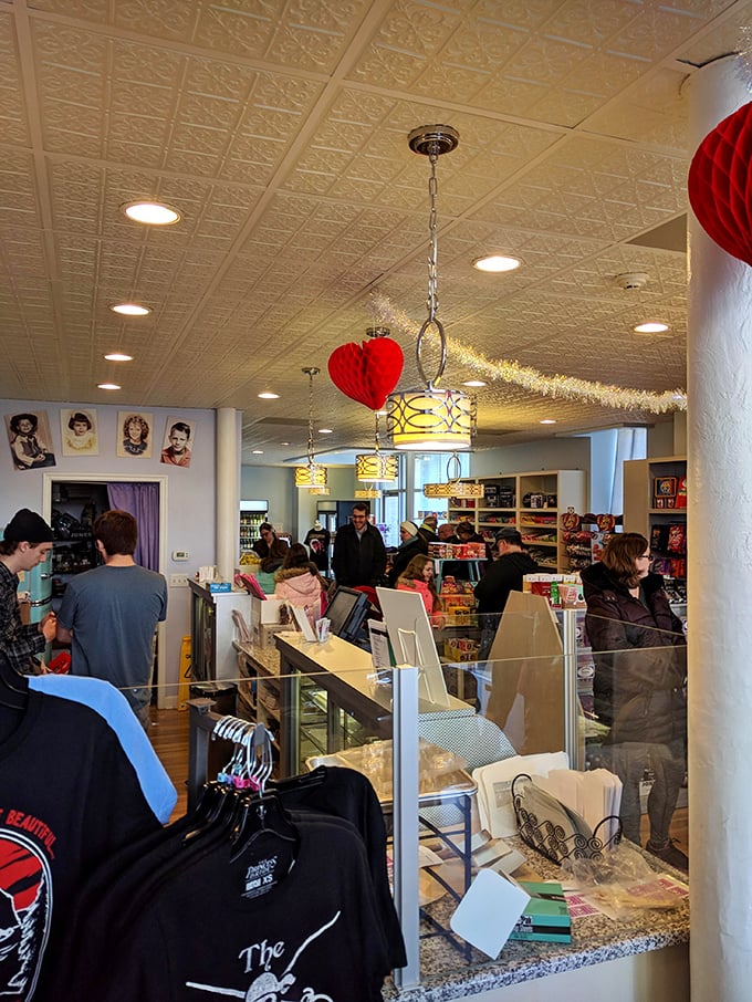 The pressed tin ceiling watches over a crowd of candy pilgrims. That red honeycomb heart isn't decoration&mdash;it's the universal symbol for "diet starts tomorrow."
