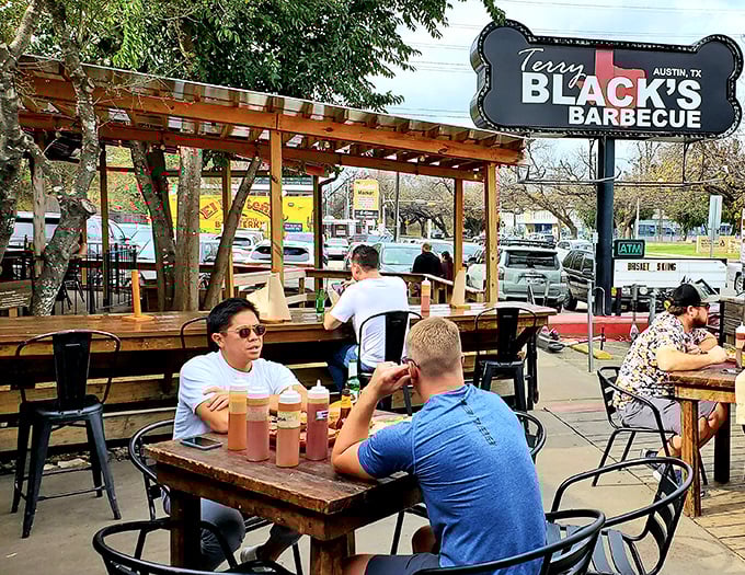 The outdoor seating area where strangers become friends united by the universal language of "mmm" and "have you tried the brisket yet?"