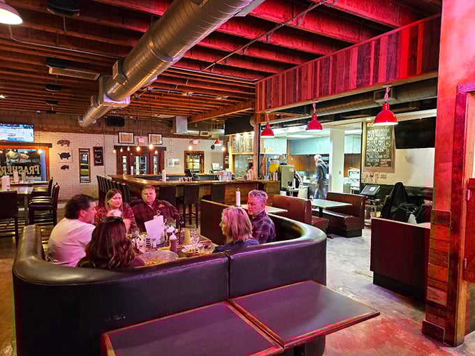 The curved booth where barbecue dreams come true. These diners aren't just eating &ndash; they're having a religious experience with smoke and fire.