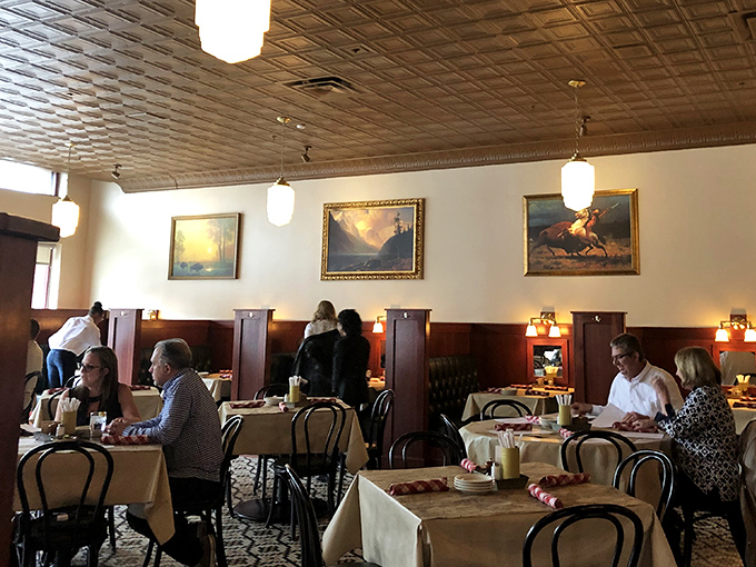 Diners settle into their booths like they're coming home, the warm wood paneling and landscape art creating the perfect backdrop for conversation.