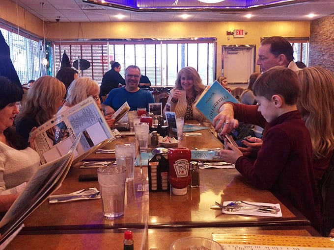 Families gathering around tables, sharing meals and making memories in true American diner tradition at its finest.