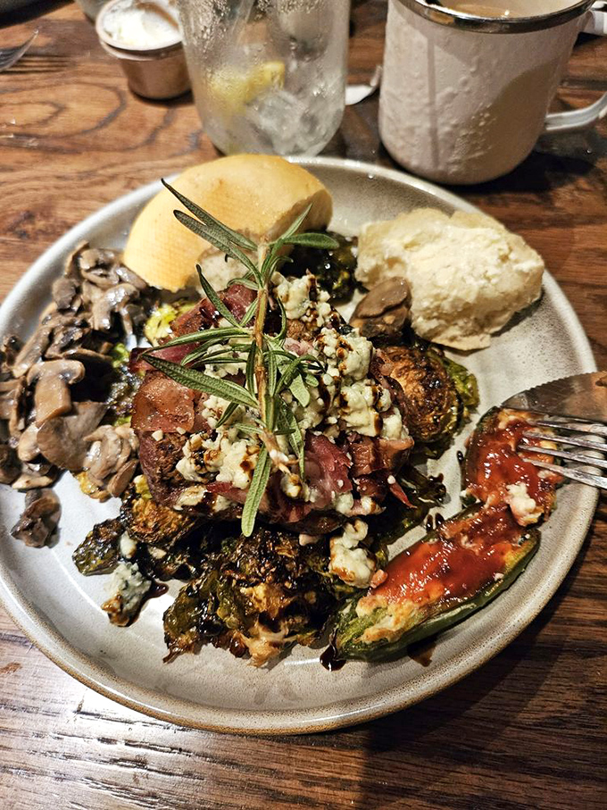 This isn't just dinner&mdash;it's a celebration on a plate. Rosemary-kissed steak, roasted vegetables, and what appears to be blue cheese crumbles form a triumphant trio.