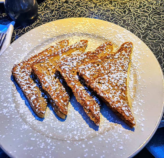 French toast dusted with powdered sugar like a light snowfall, perfectly golden and waiting to be drenched in maple syrup. Breakfast of champions at any hour.