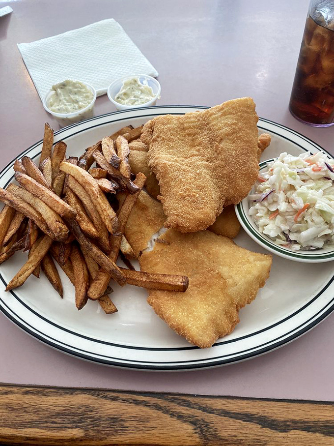 Fish so perfectly golden it belongs in Fort Knox, with fries that could start their own fan club. Coleslaw provides the token vegetable presence.