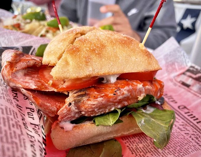 This sandwich isn't just food; it's architecture. Layers of perfectly grilled salmon nestled between bread with enough heft to handle all that deliciousness.