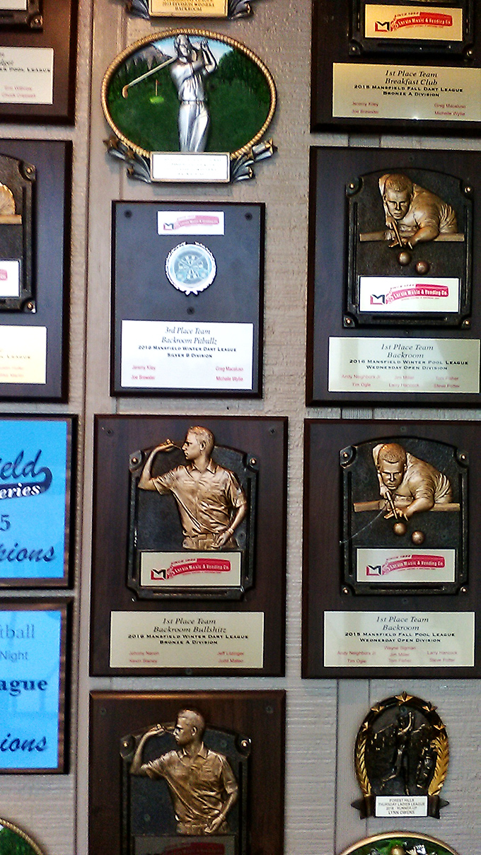 The wall of fame showcases local league victories, proving Backroom nurtures both community champions and championship-worthy appetites.