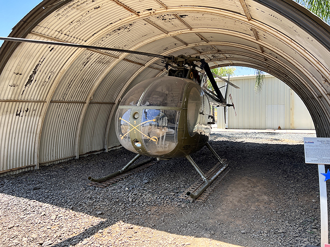 The bubble-nosed observation helicopter sits in its protective hangar like a curious insect, its transparent cockpit revealing the surprisingly simple controls within.
