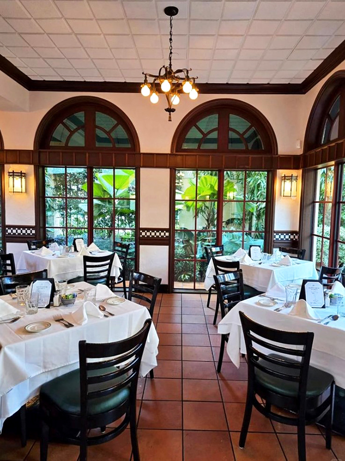 Arched windows frame lush greenery outside while diners inside debate the important questions: one more crab claw or save room for pie?