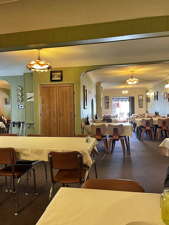 Tiffany-style lamps cast a warm glow over tables dressed in white, creating the perfect backdrop for the comfort food theater about to unfold.