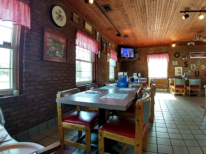 The wooden ceiling, red gingham curtains, and brick walls create that timeless small-town pizzeria vibe that chains spend millions trying to replicate.