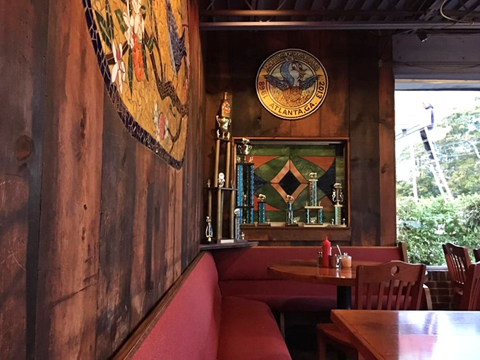 Red booth seating and wooden walls create that perfect diner-meets-cabin vibe. Those trophies? Evidence that breakfast can be competitive sport. 