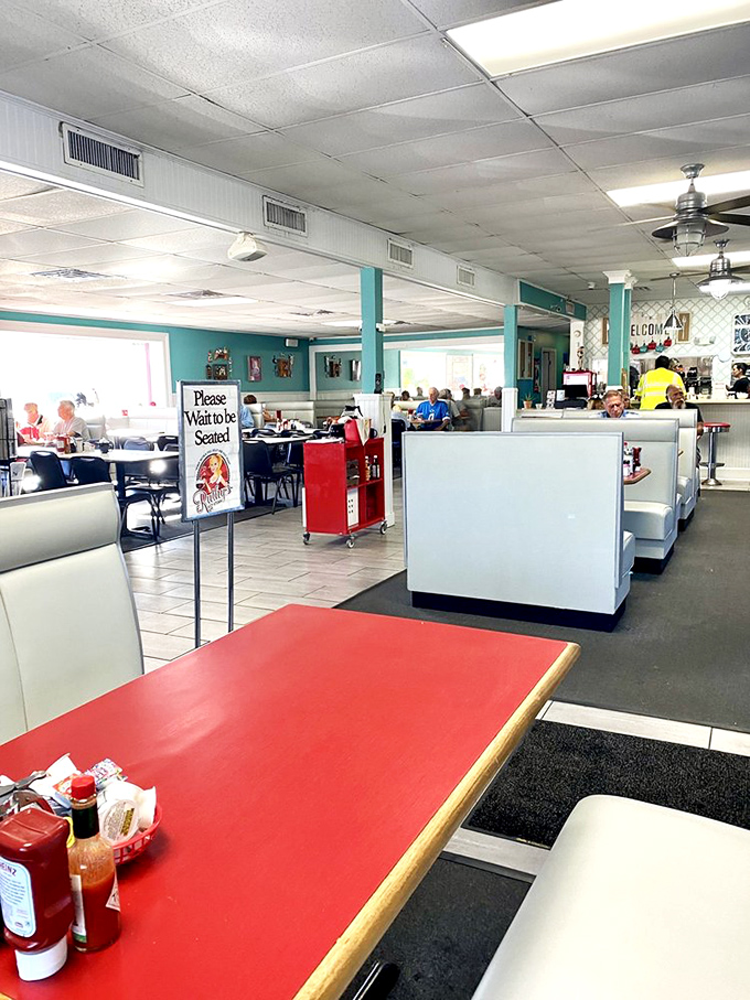 The bright, open dining area balances no-nonsense functionality with unexpected charm. That "Please Wait to be Seated" sign is worth obeying.