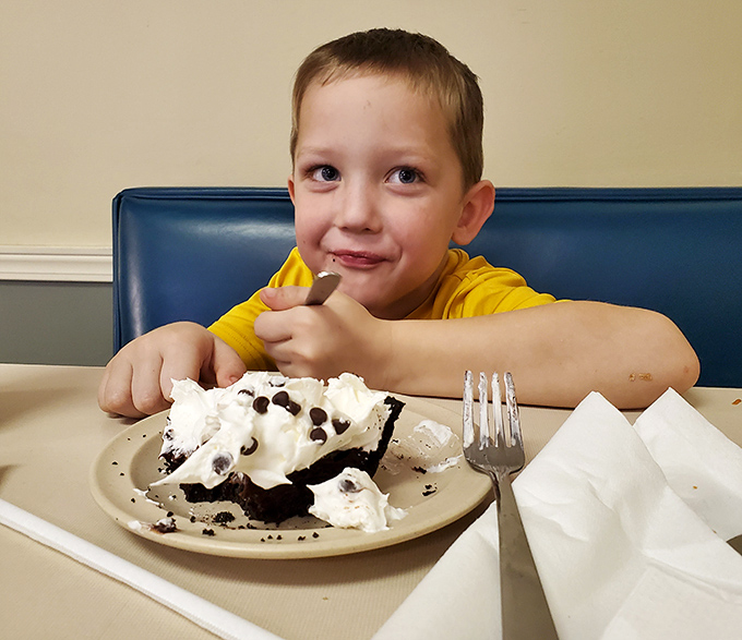 Pure childhood joy captured in chocolate cream pie—proof that the best food critics are often under four feet tall with chocolate-smeared grins.