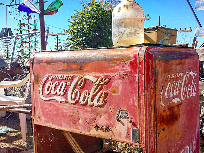 A rusty Coca-Cola cooler stands sentinel, reminding visitors that even commercial artifacts can become folk art treasures.