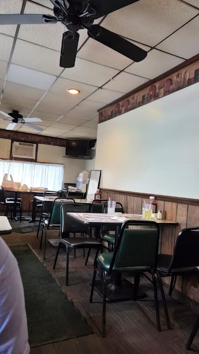 Classic green chairs and wood-paneled walls create that timeless diner atmosphere where comfort food and comfortable conversations have equal billing.