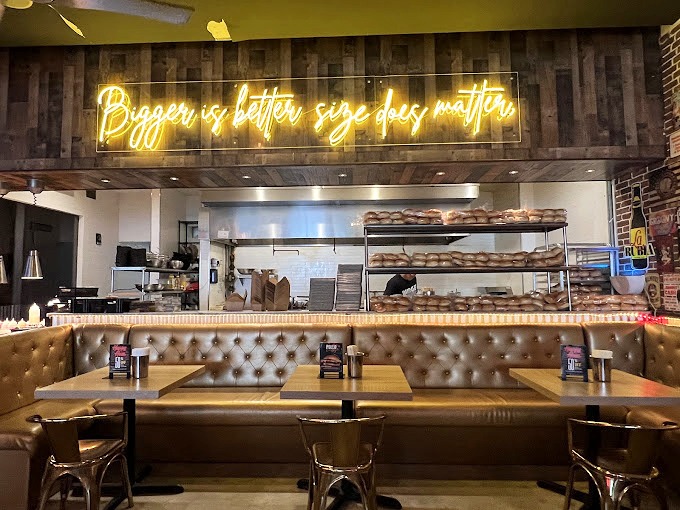 The neon declaration "Burger is better with friends" isn't just decor&mdash;it's a life philosophy backed by cushioned booths and ambient lighting.