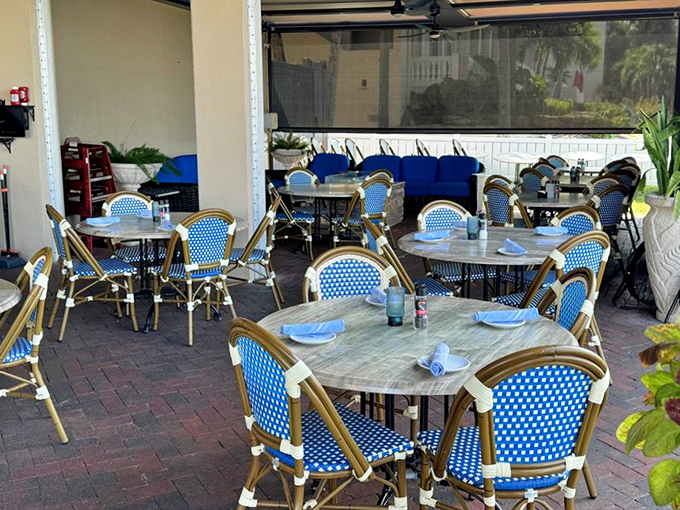 Blue bistro chairs that practically whisper "sit here with a cocktail and forget your troubles" on the breezy outdoor patio.