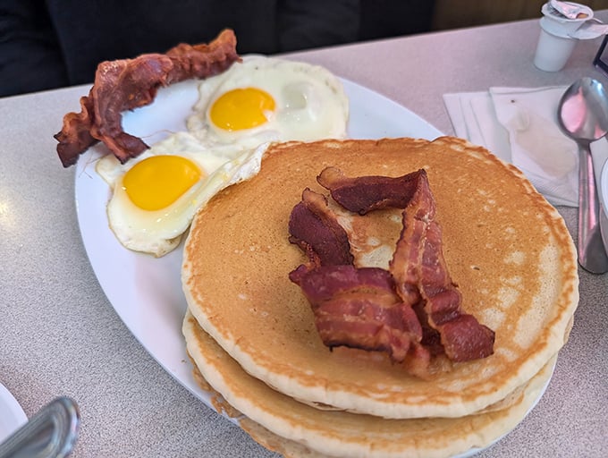 Stack of pancakes topped with bacon shows that some combinations are simply too good to question or improve.