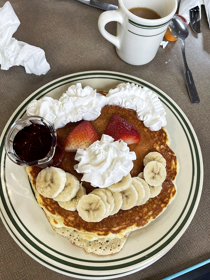 Pancakes adorned with fresh fruit, whipped cream, and possibility. That little cup of syrup is just waiting to transform your breakfast from delicious to transcendent.